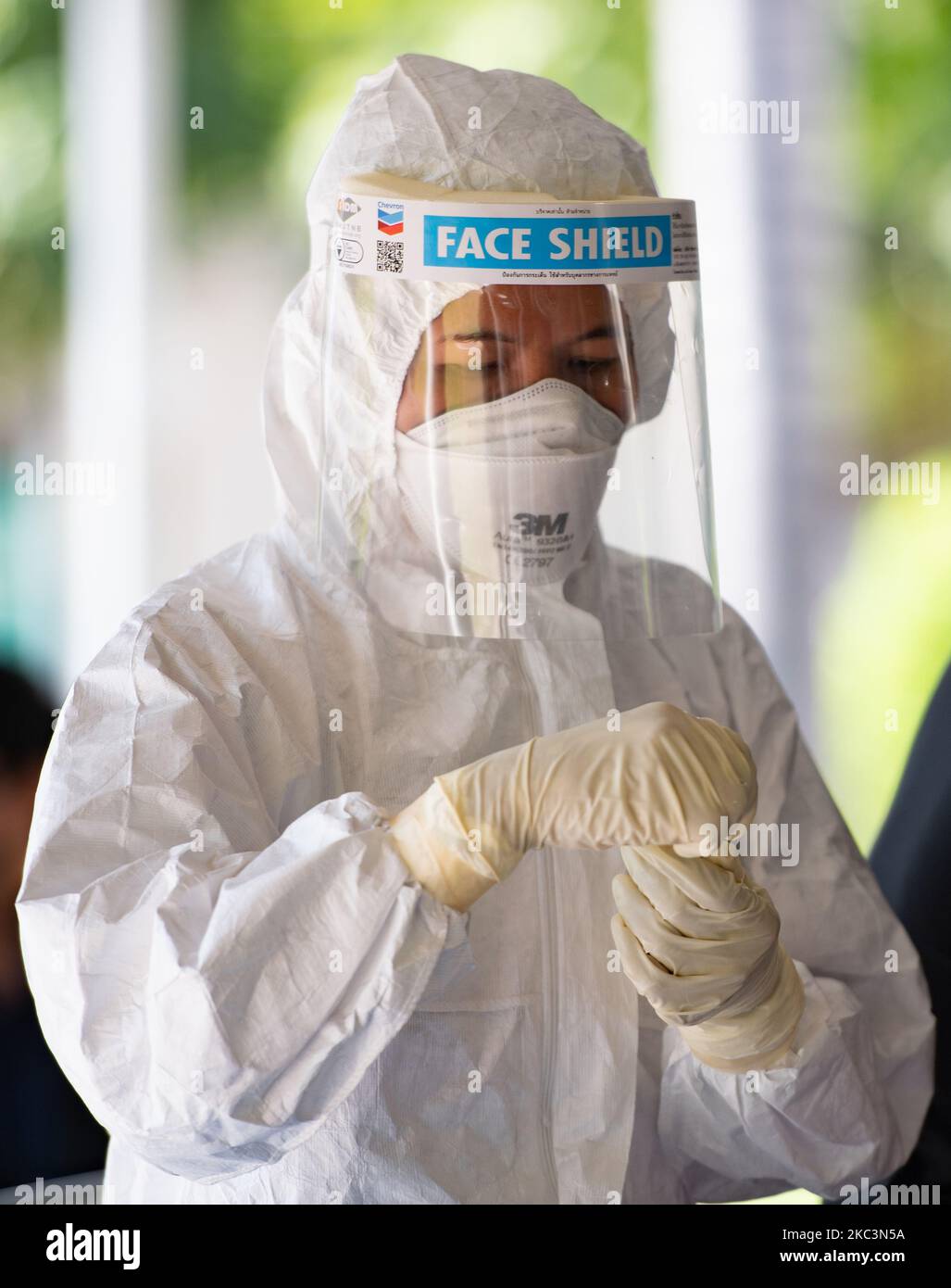 A health worker wearing personal protective equipment (PPE) handles ...