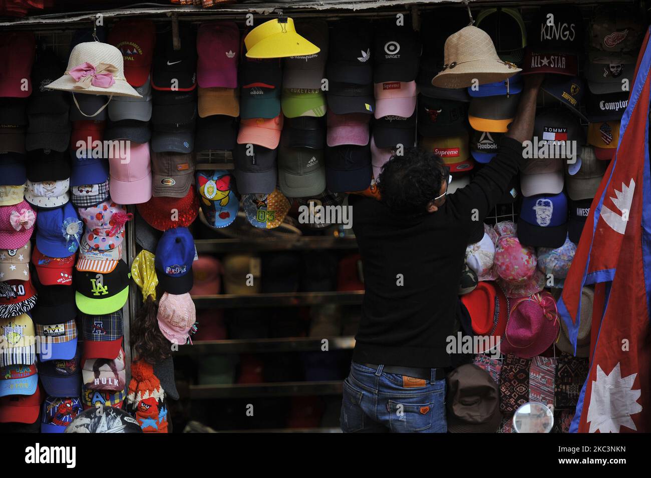 A vendor arranging different type of caps in the market at Ason ...