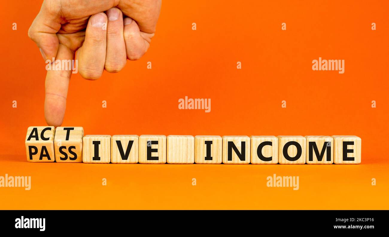 Passive or active income symbol. Businessman turns wooden cubes and ...