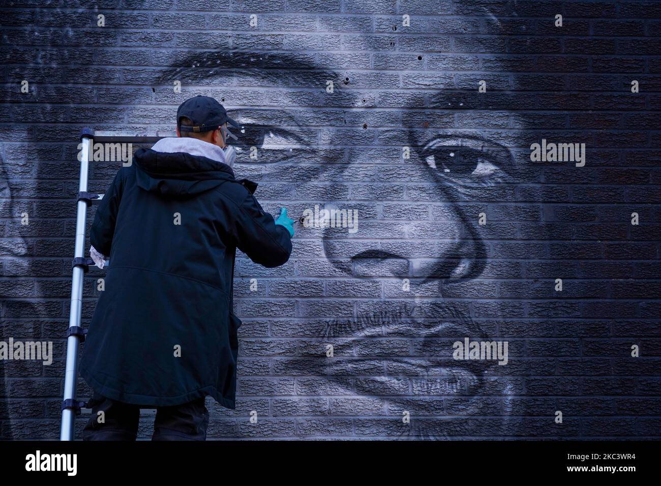 Street artist, AKSE, puts the finishing touches to his mural of ...