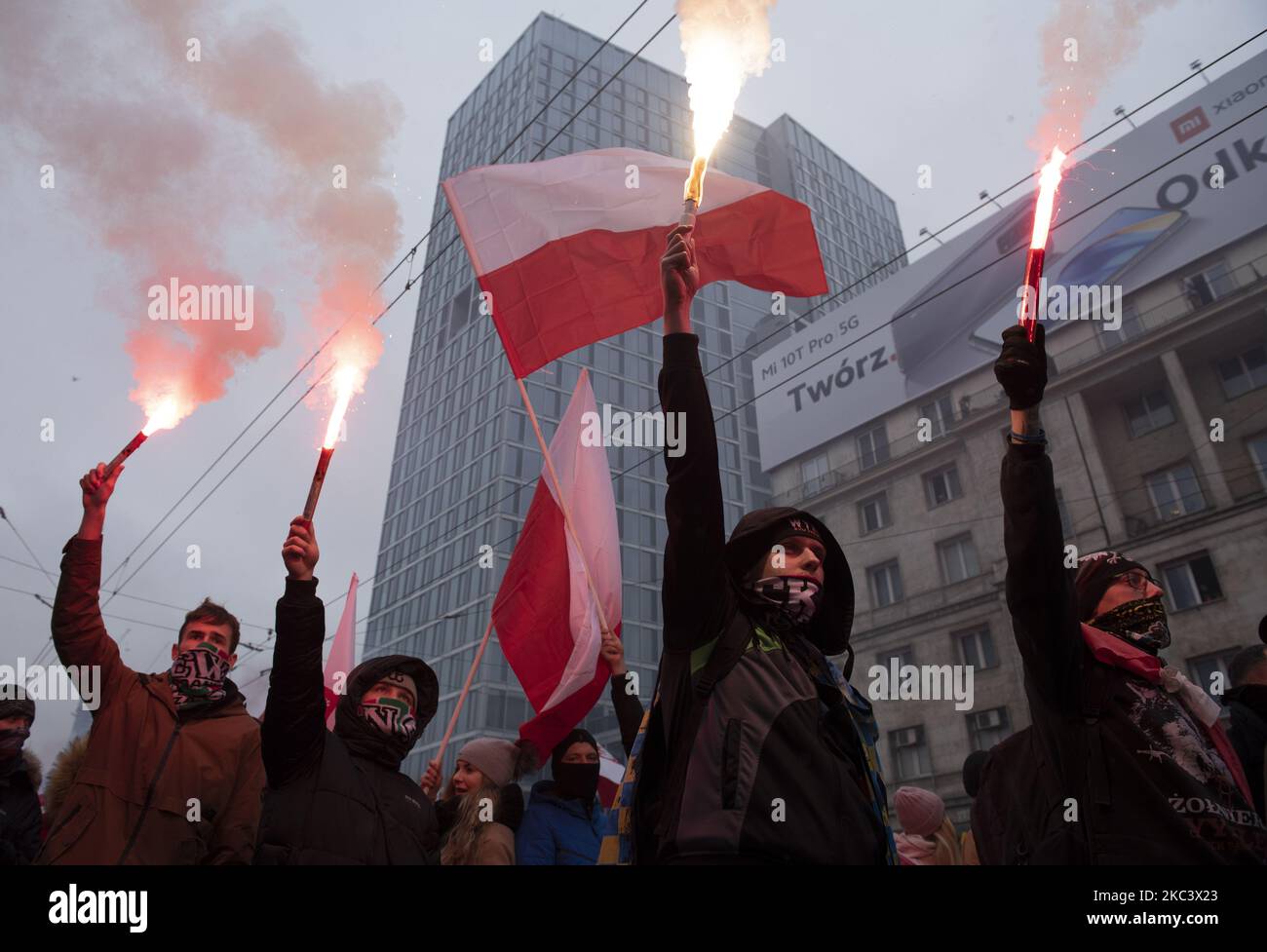 People hold flares and wave Polish flags during Poland's Independence ...