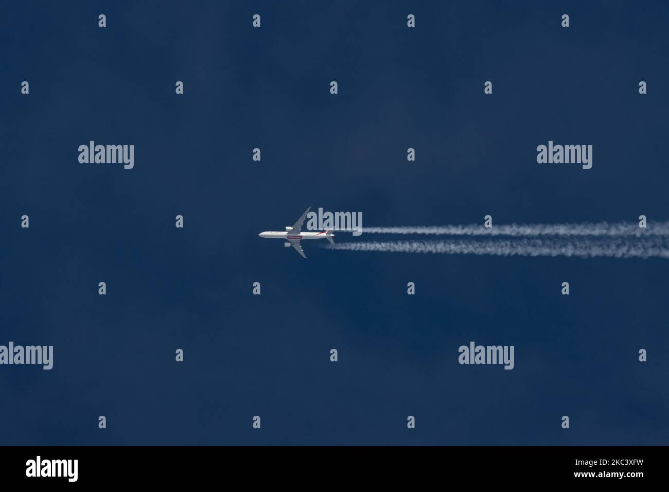 An Emirates Boeing 777 passenger aircraft flying in the blue sky at 39. ...