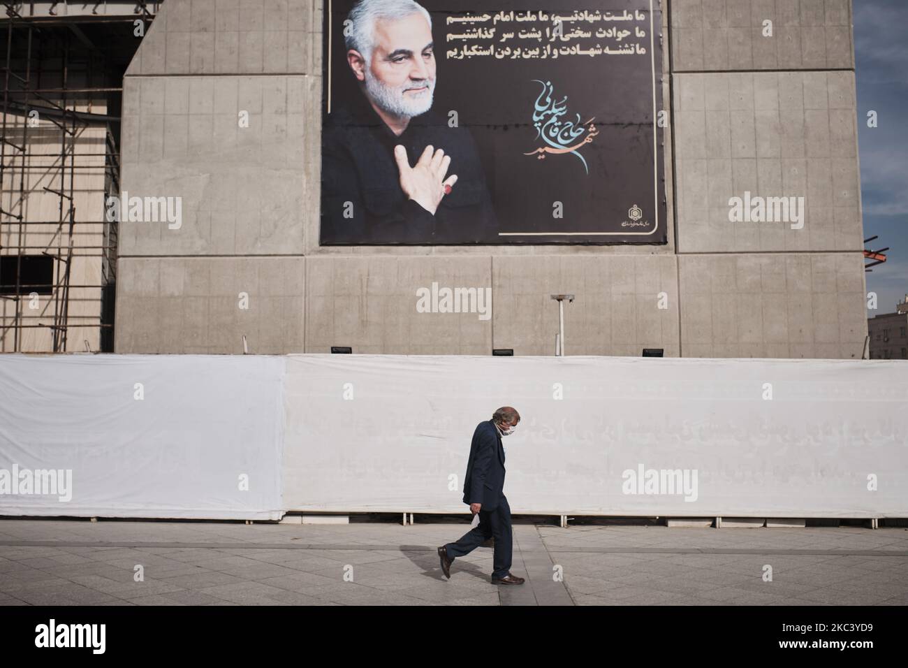 An Iranian elderly man wearing a protective face mask walks under a ...