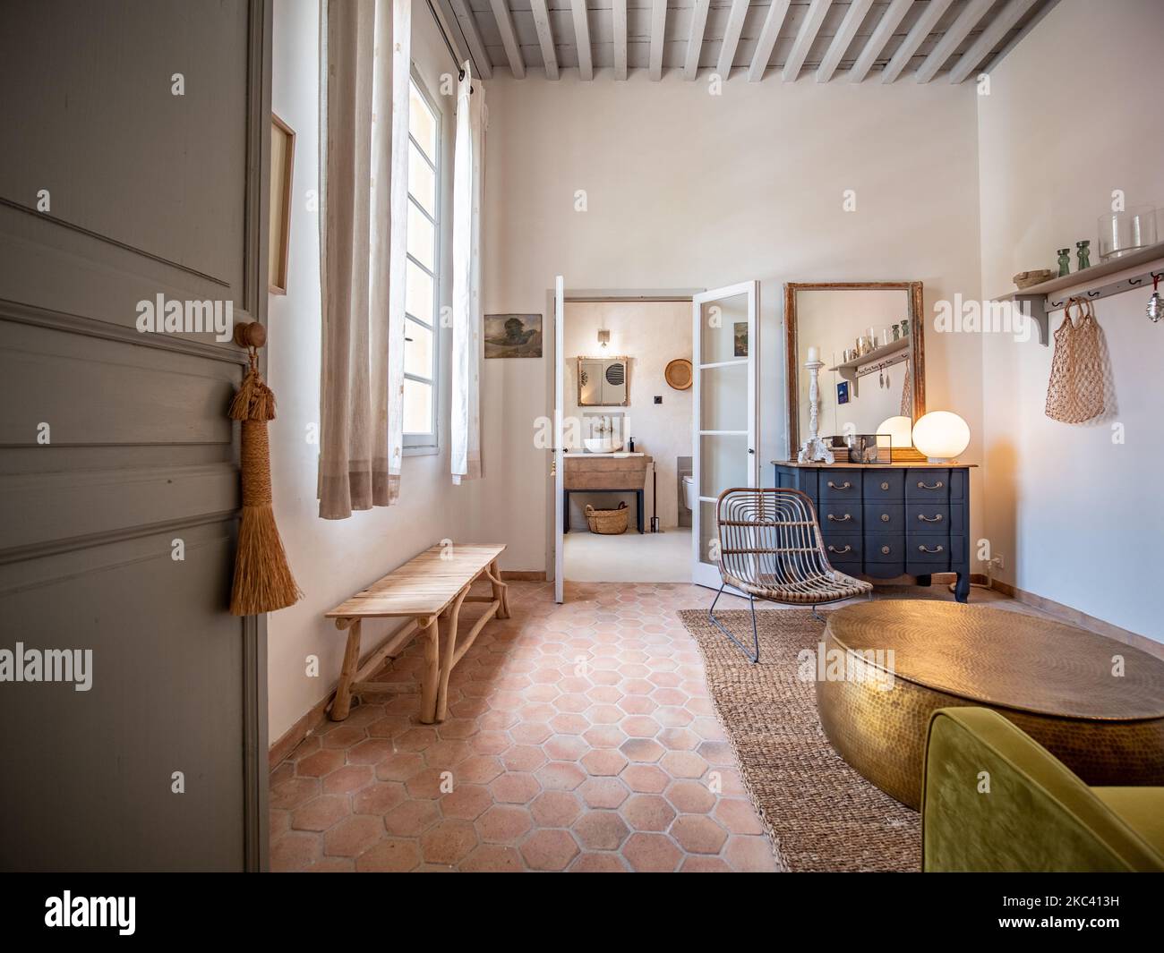 A small vintage room with a wicker chair, a bench, a vintage armchair ...
