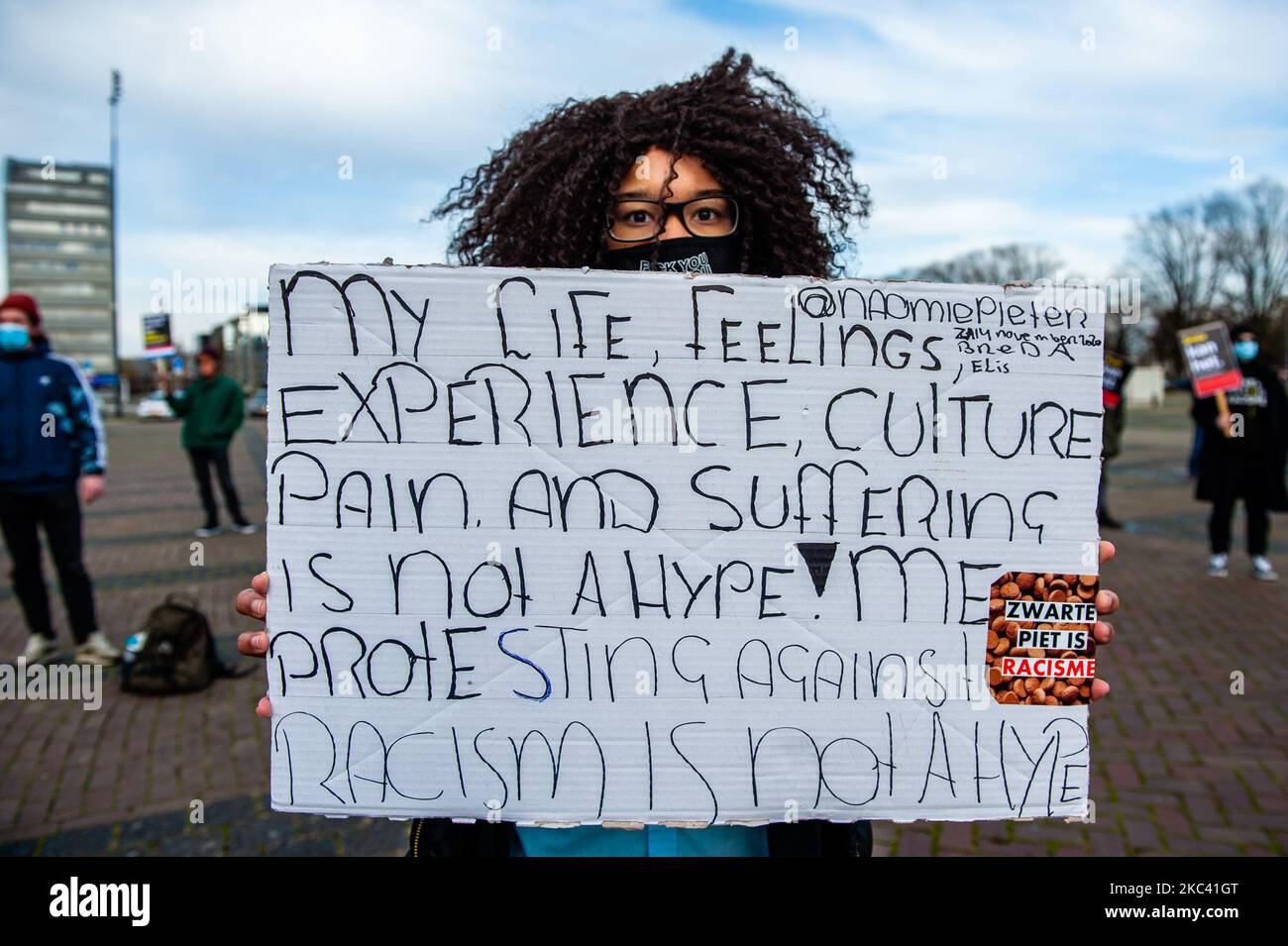 A Black woman is holding a placard against racism, during the anti ...