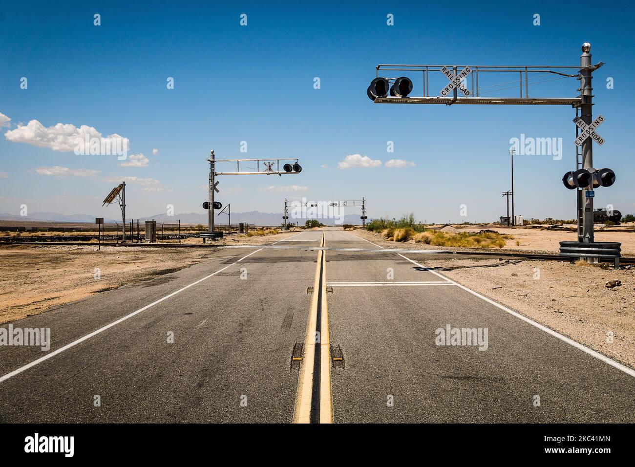 The railroad crossing in Arizona with road signs under the blue sky ...