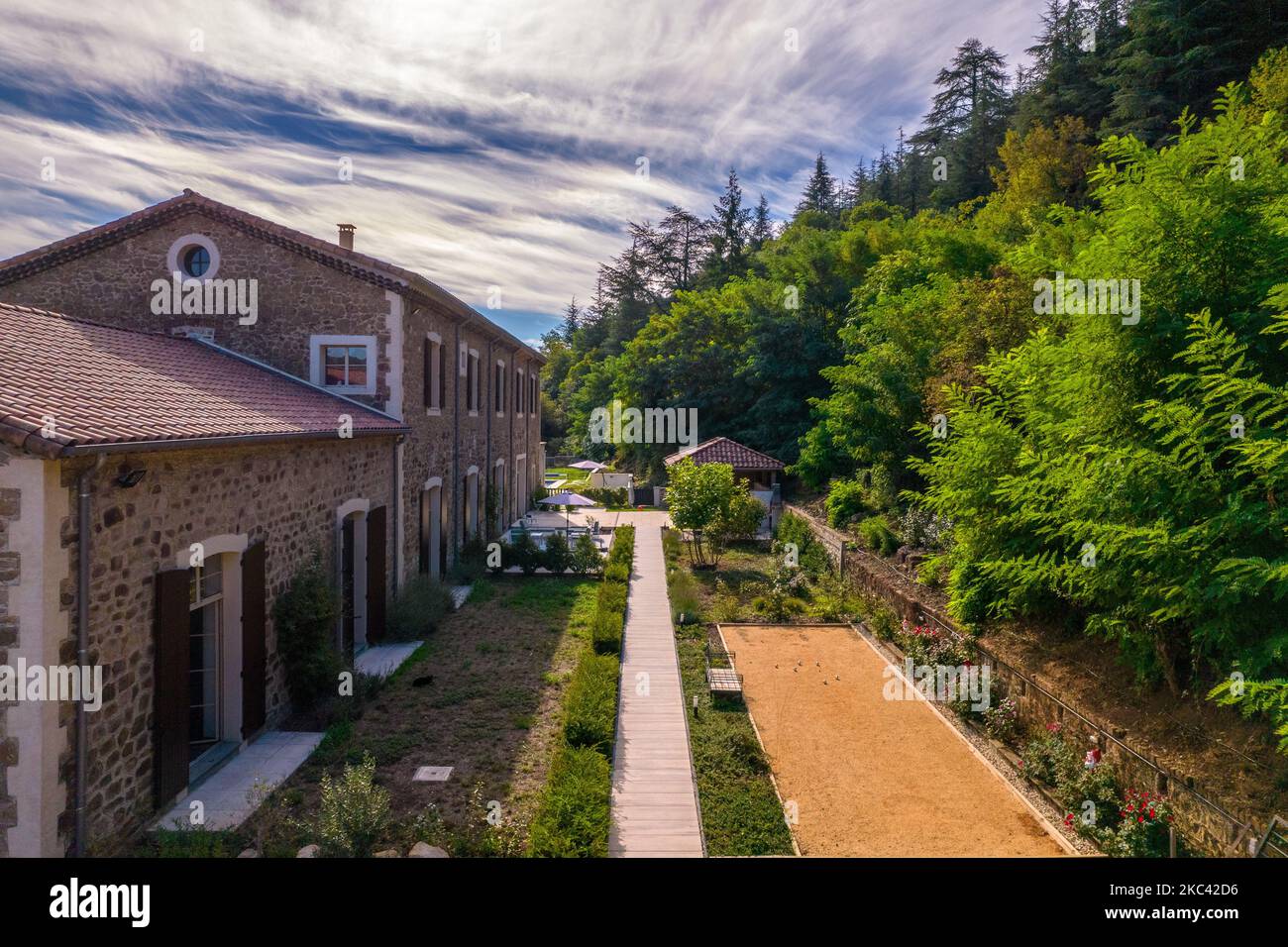 An aerial view of an exterior of a big house surrounded by trees and ...