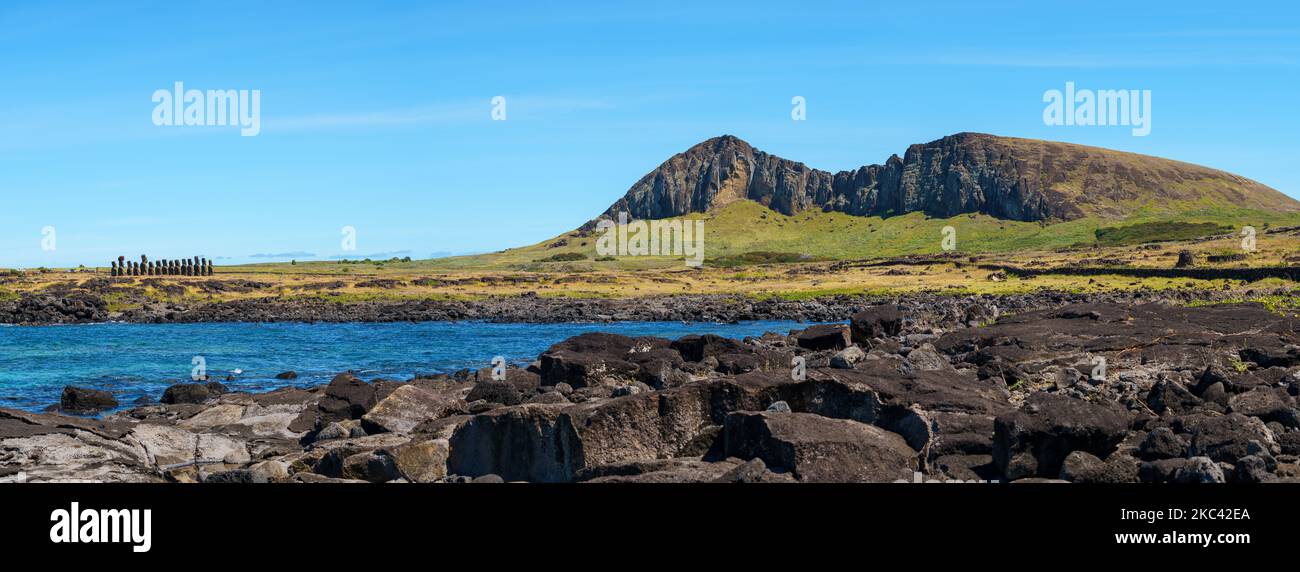 The Moai stone monolithic statues in a row surrounded by mountains and ...