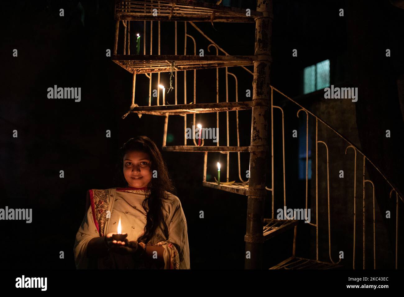 A Hindu devotee lights lamps on the occasion of Diwali, the largest ...