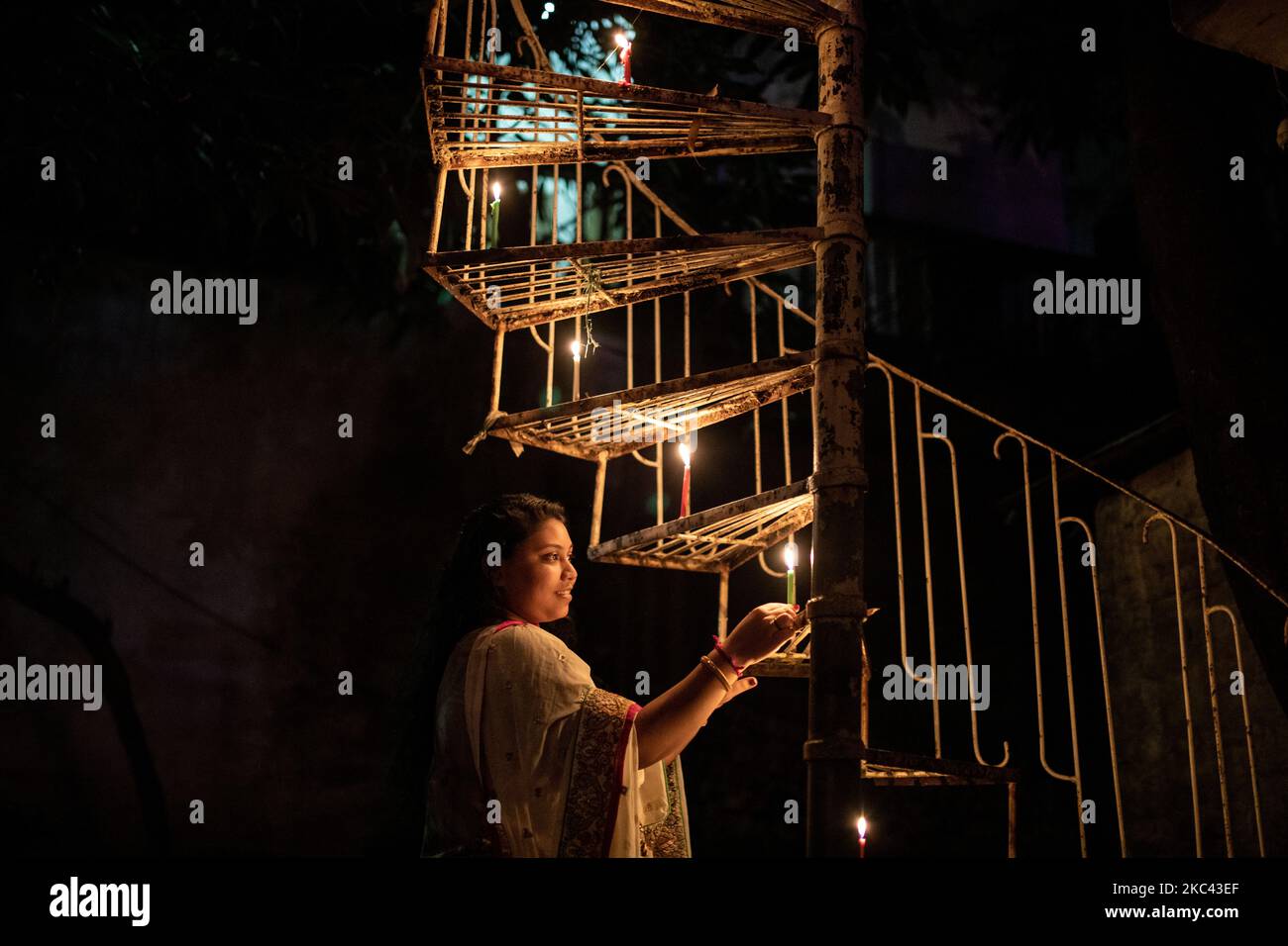 A Hindu devotee lights lamps on the occasion of Diwali, the largest ...