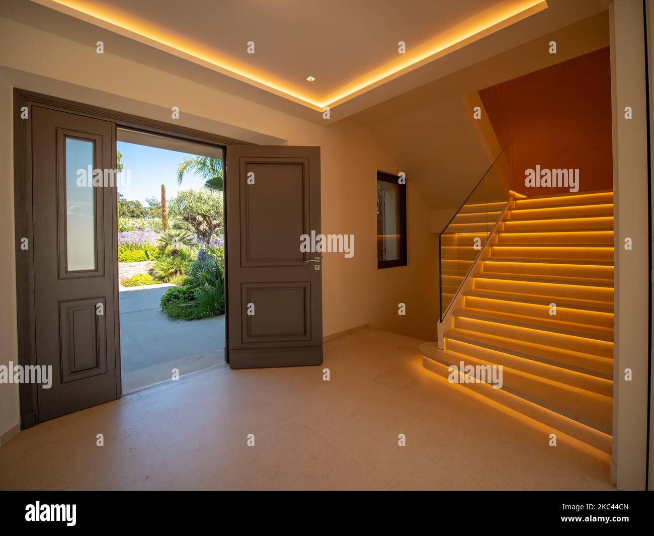 An interior of a luxurious villa with an open entrance door and a ...
