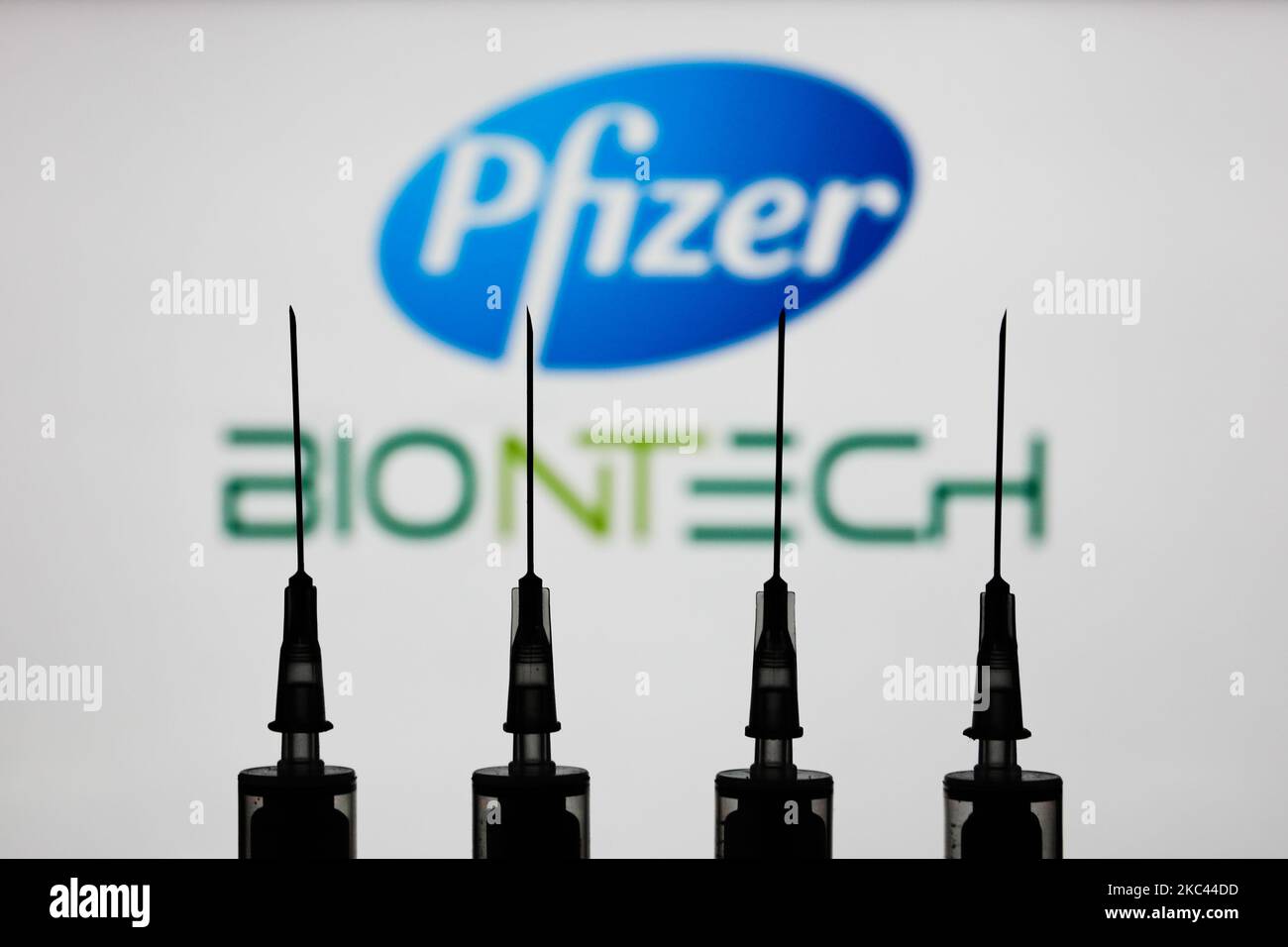 Medical syringes are seen with Pfizer and BioNTech companies logos ...