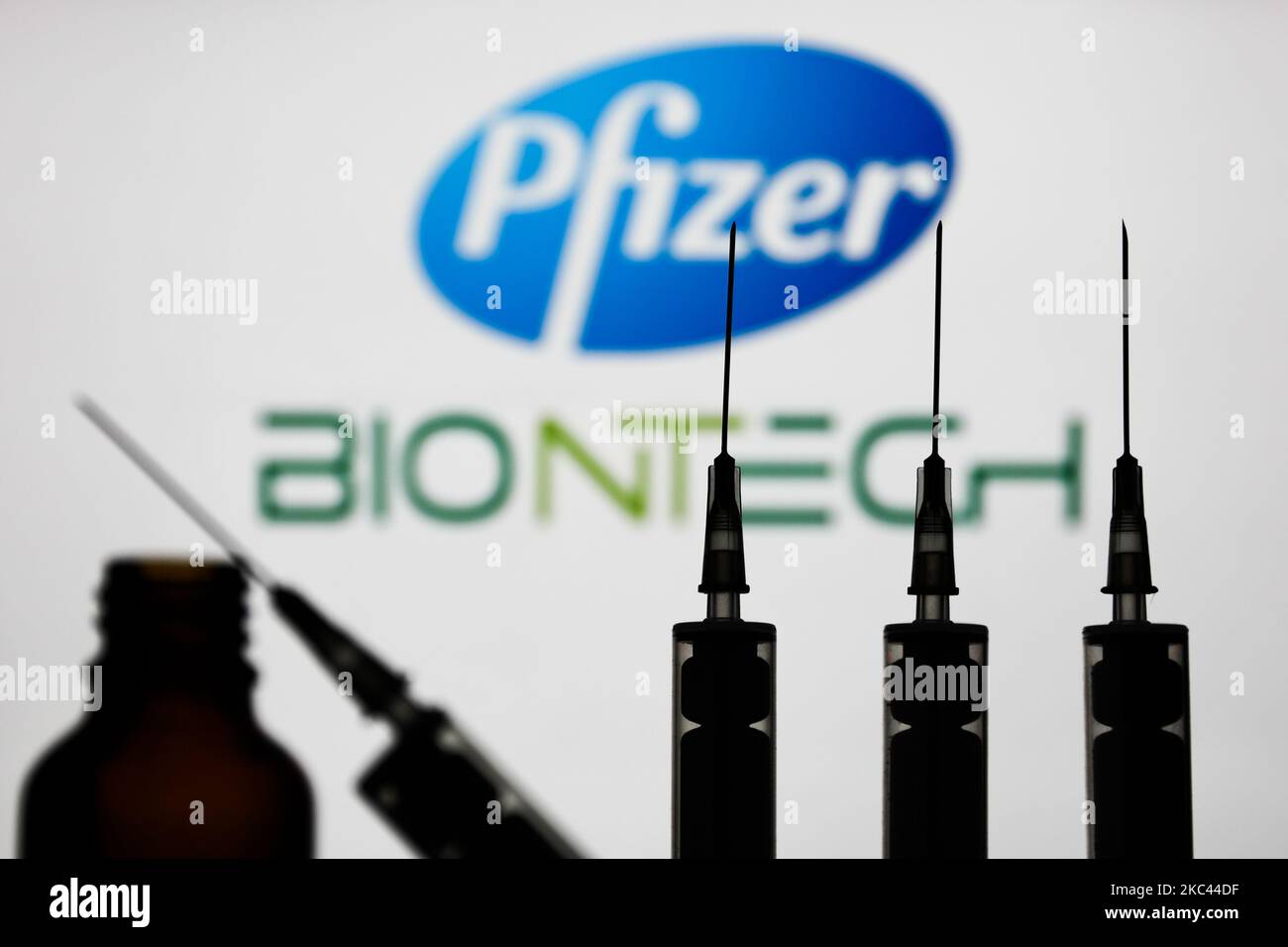 Medical syringes are seen with Pfizer and BioNTech companies logos ...
