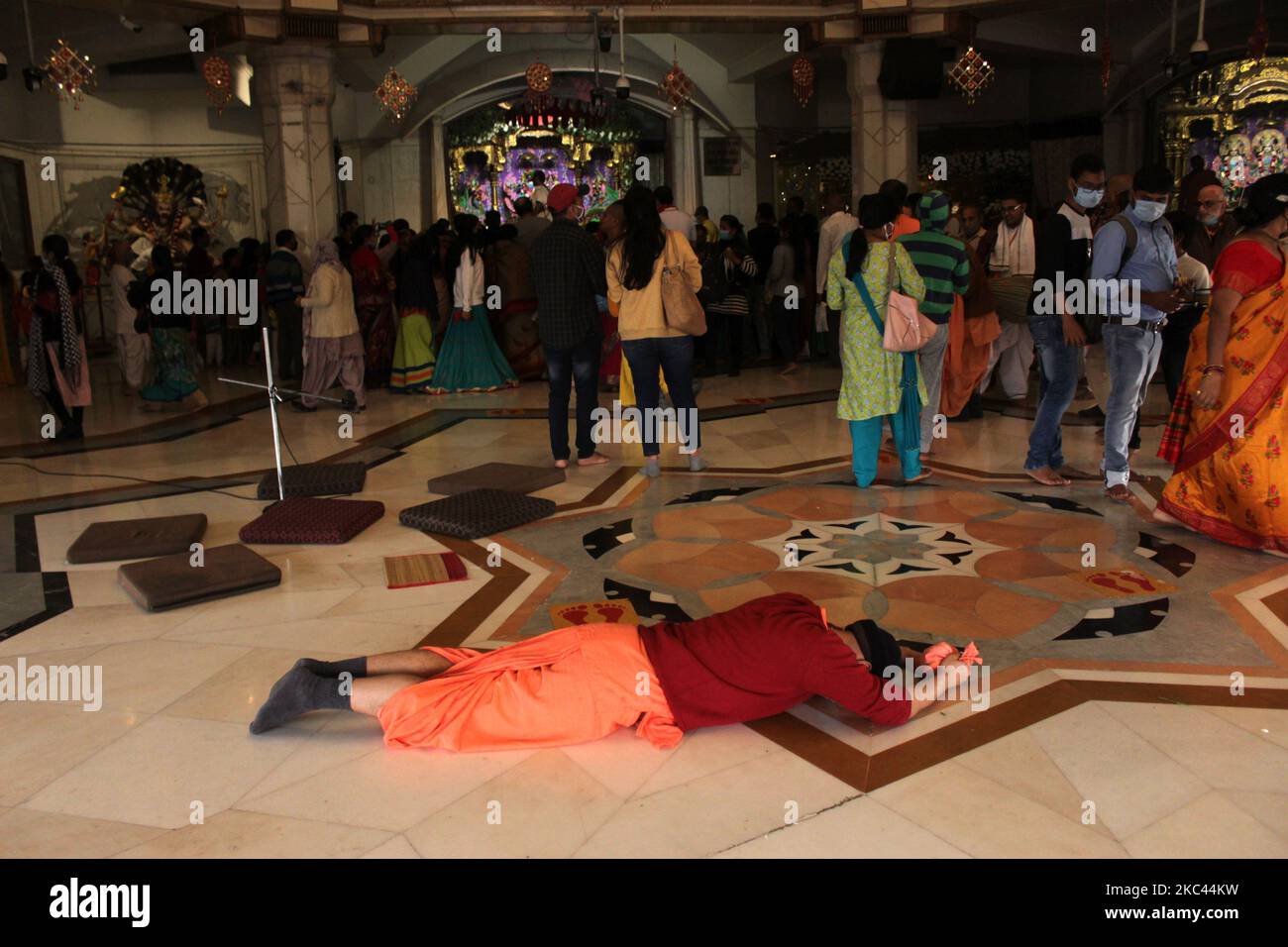 A devotee lies down on floor as he offers prayers inside Iskcon temple ...
