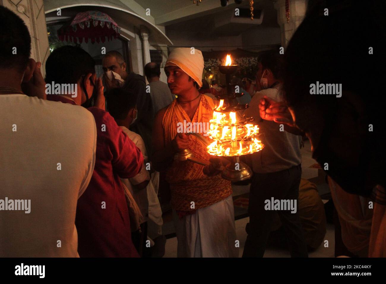 Devotees move their hands towards the flames presented by a priest ...