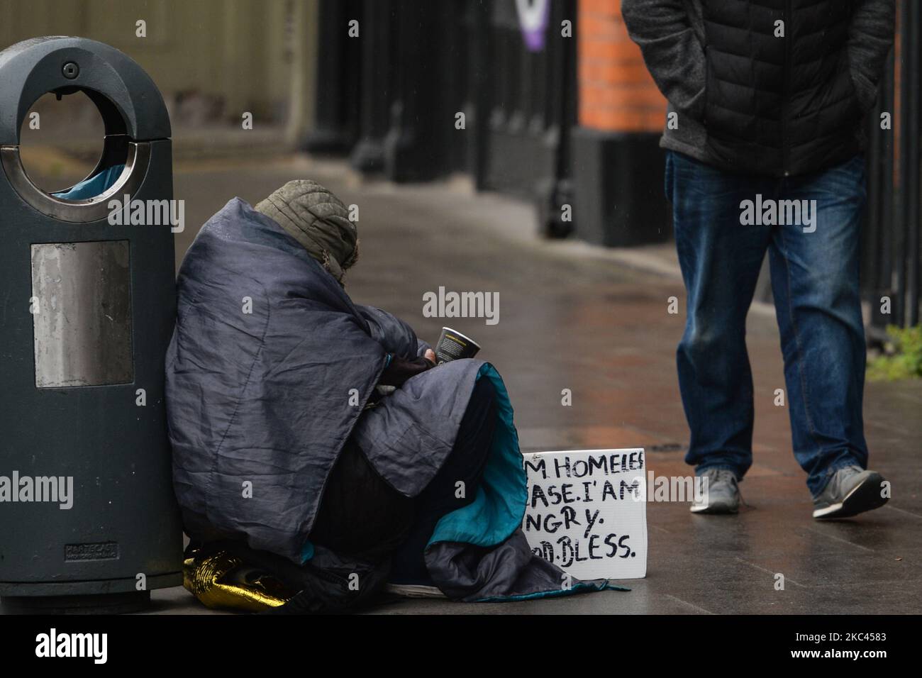 A homeless person begging on a street in the center of Dublin. On ...