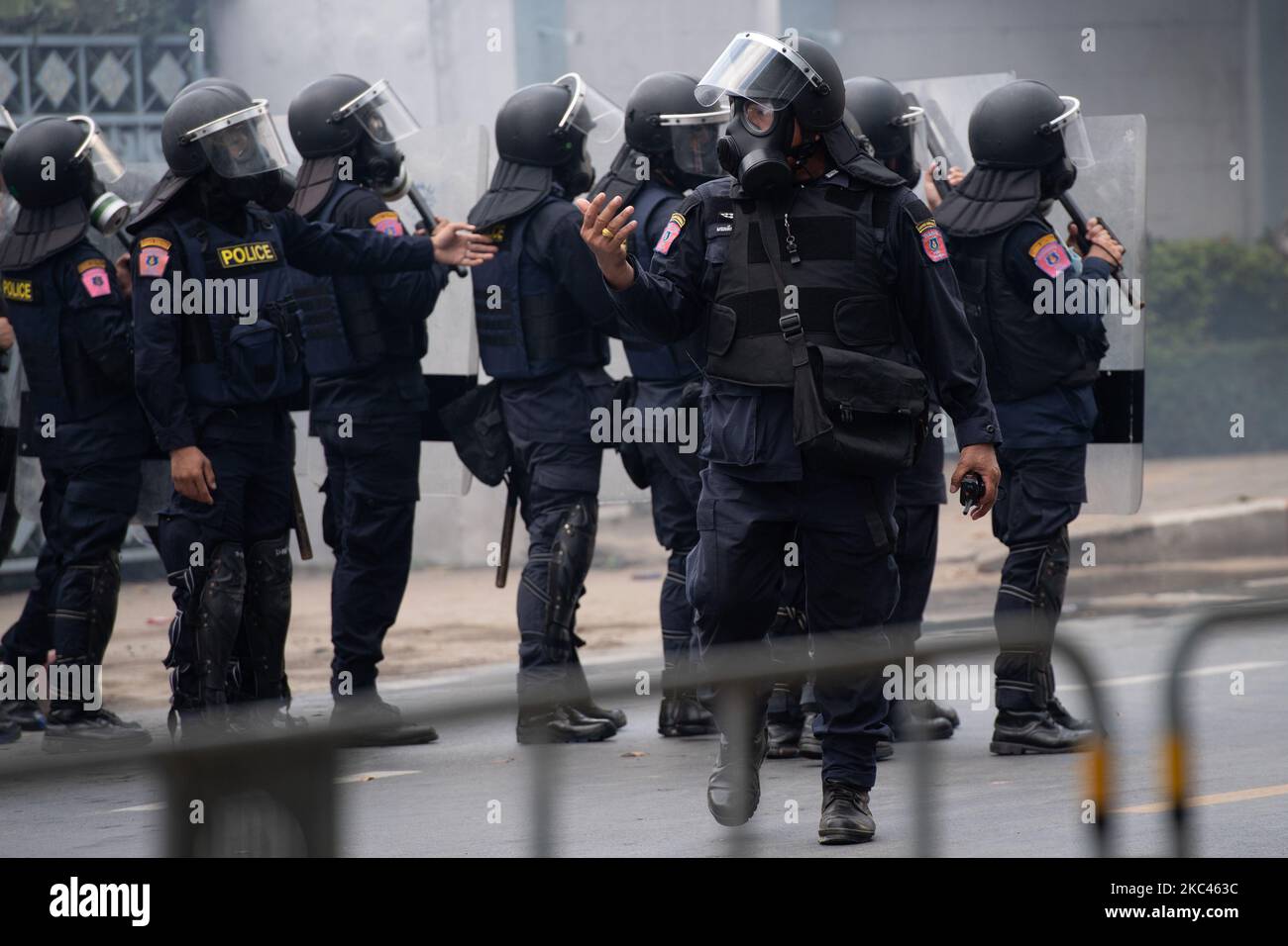 Riot police wear gas masks and anti-riot gear walk in formation during ...