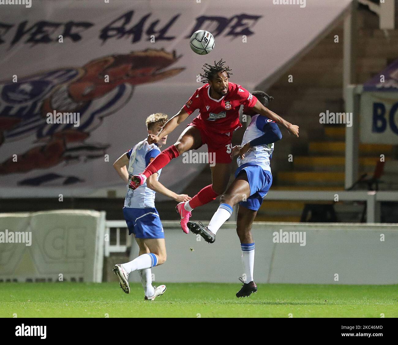 Kwame Thomas of Wrexham contests a header with Tyler Magloire of ...
