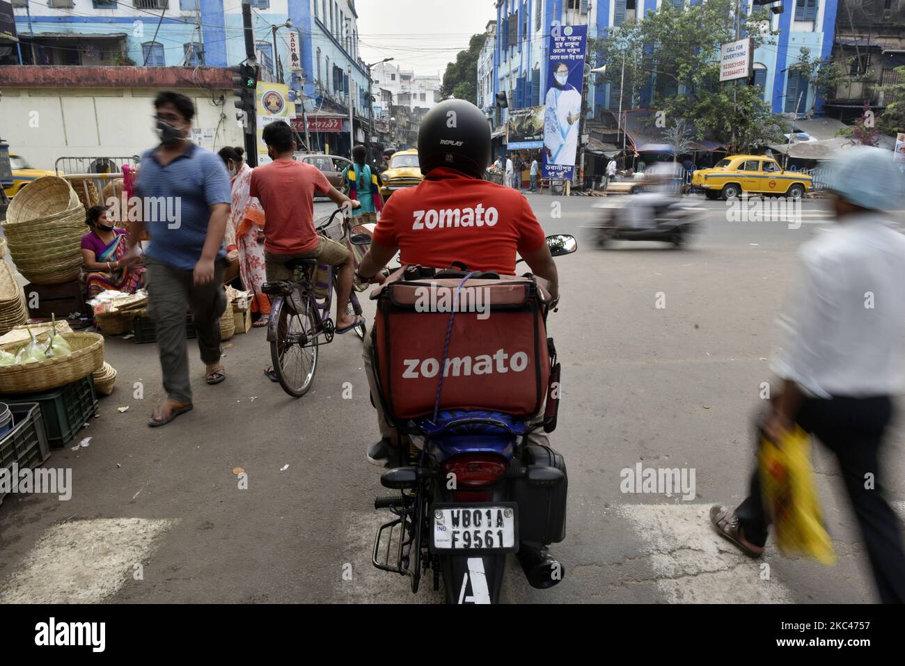 A Zomato delivery boy waits to cross a road in Kolkata, India, 18 ...