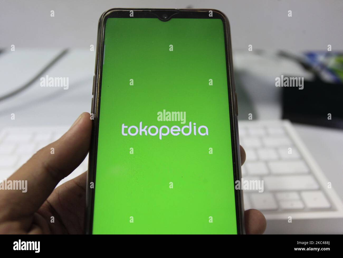 In this photo illustration, a cell phone featuring the Tokopedia logo ...