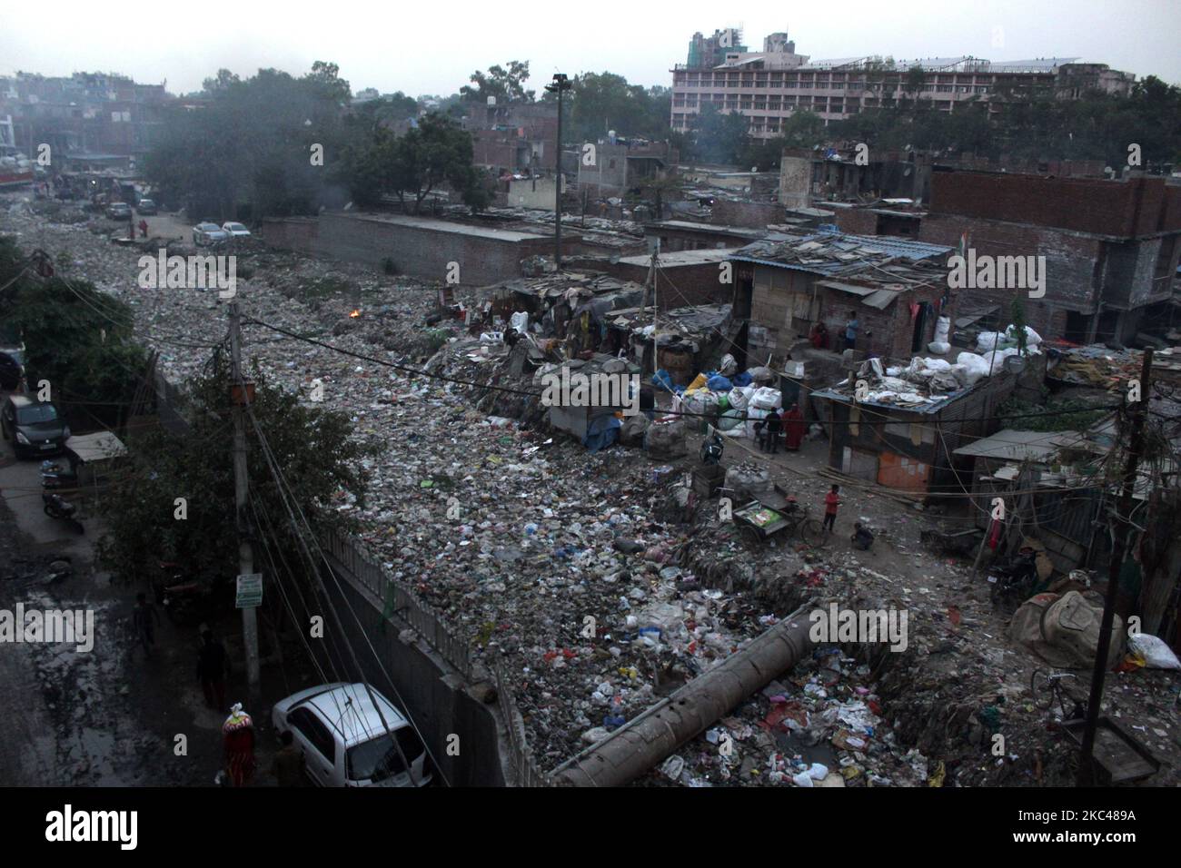 An aerial view of a slum cluster showing a sewage drain canal full of ...