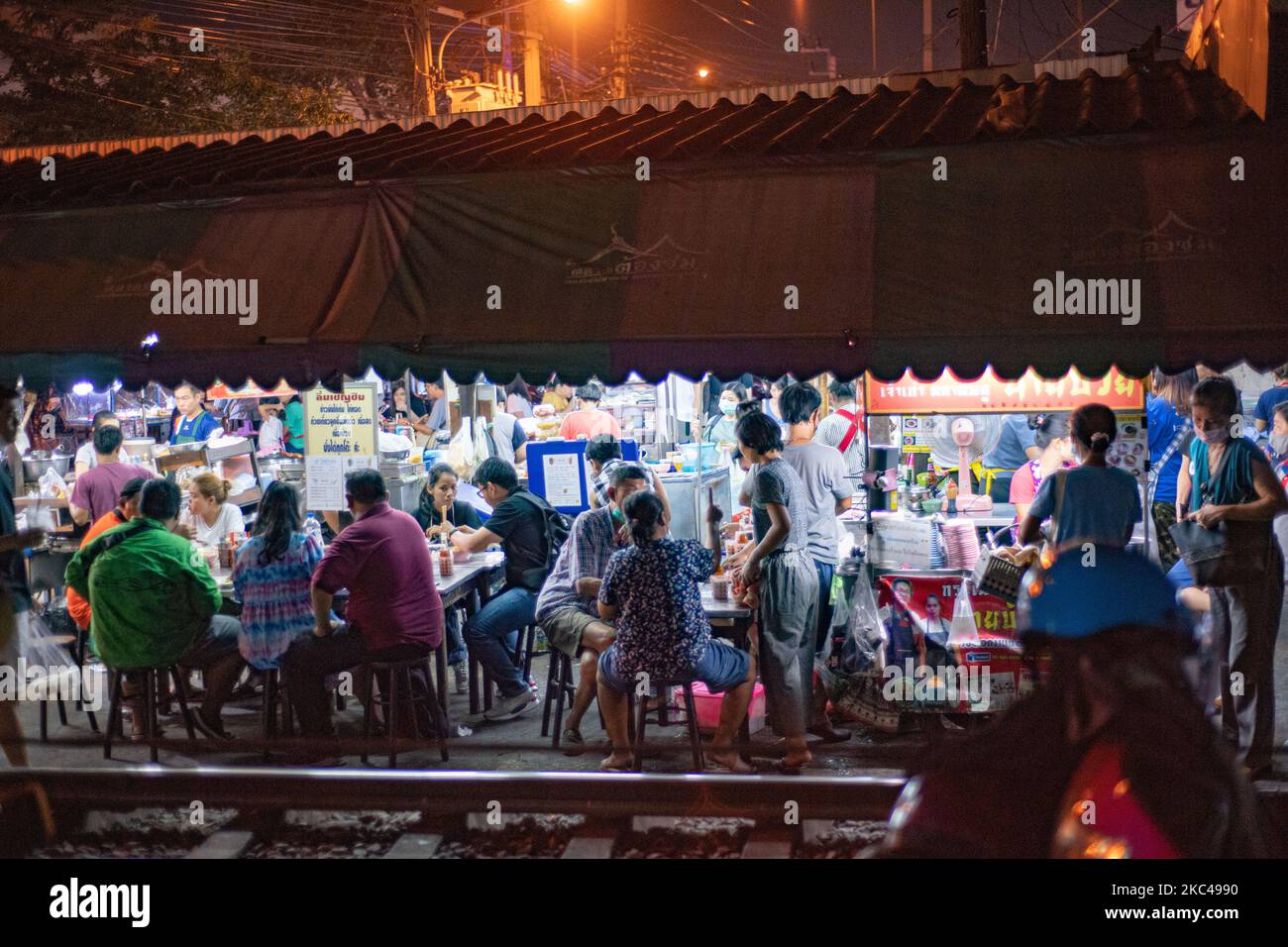 A view of street food stalls on side of railway track in Talat Phlu ...