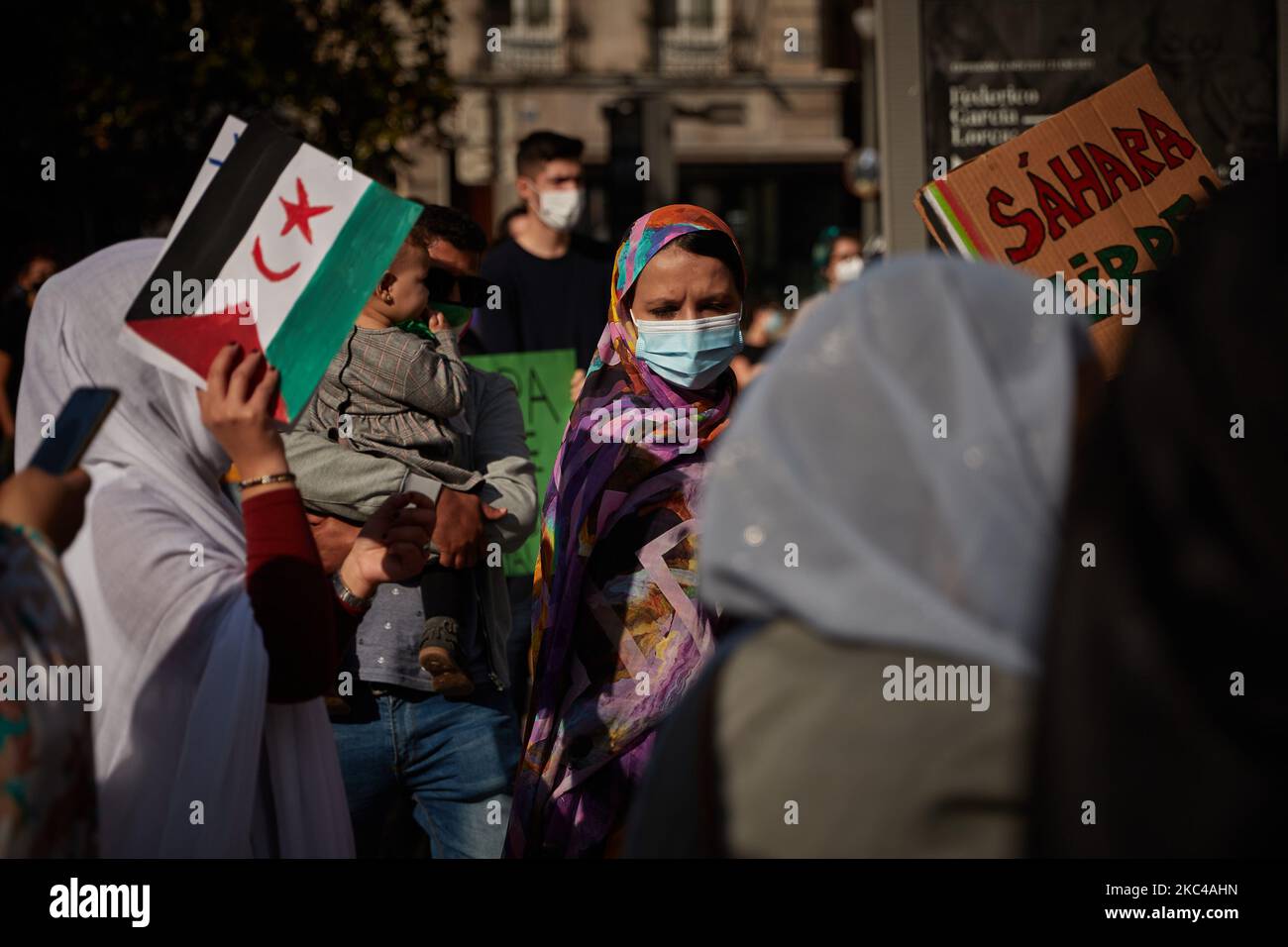 Women wearing face mask carrying a Saharan flag, placards and dressed ...
