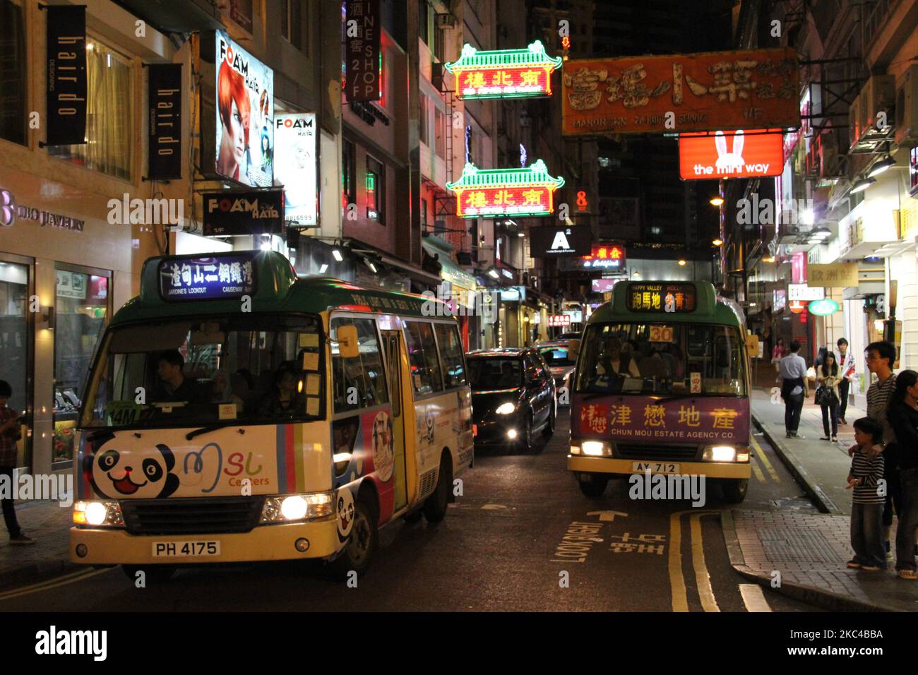 A crowded busy street with lots of buses in the evening in downtown ...