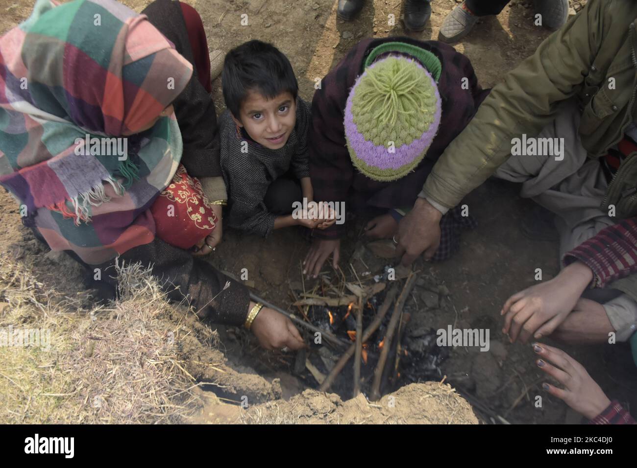 Kashmiri nomad people warm themselves on the hills of Zabarwan on the ...