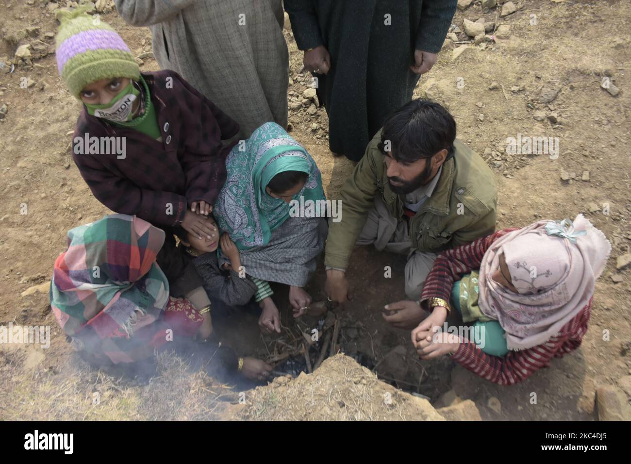 Kashmiri nomad people warm themselves on the hills of Zabarwan on the ...