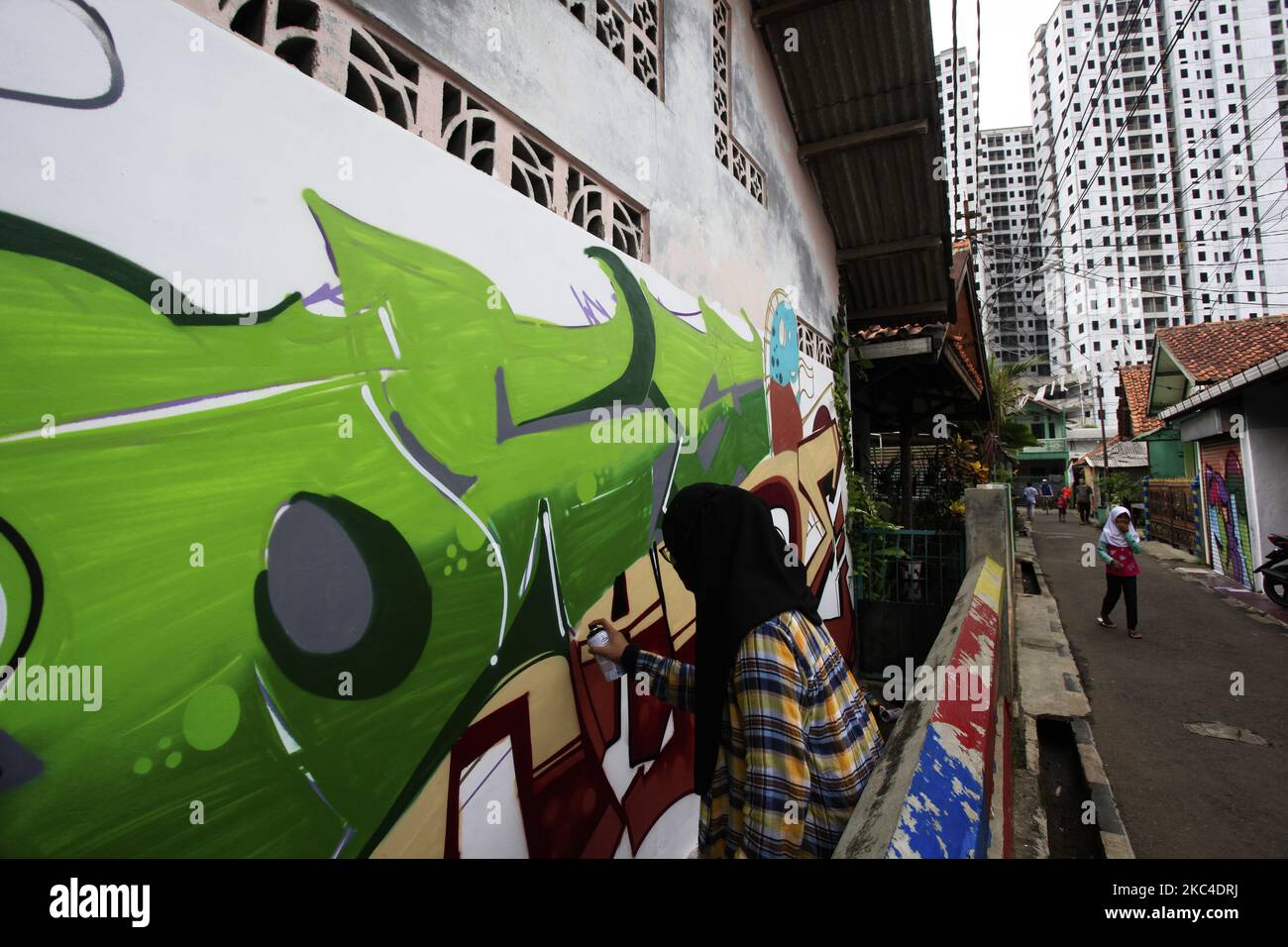 An Indonesian local artists drew graffiti on the walls of the houses ...