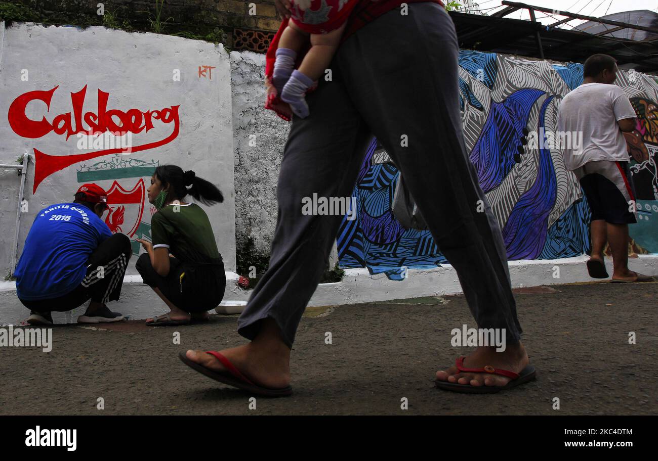 An Indonesian local artists drew murals on the walls of the houses for ...