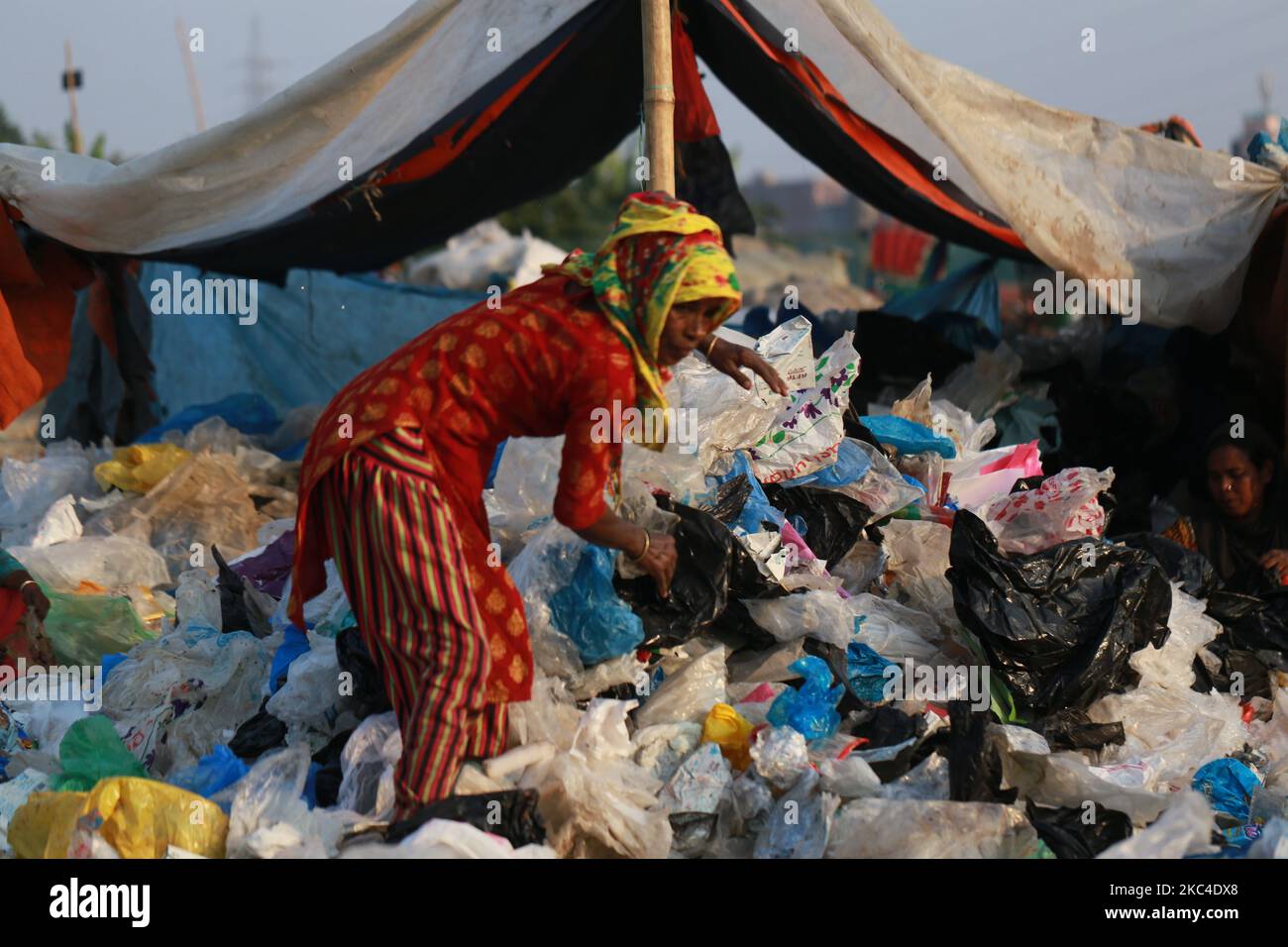 A woman drying plastics for recycling in Dhaka, Bangladesh on November ...