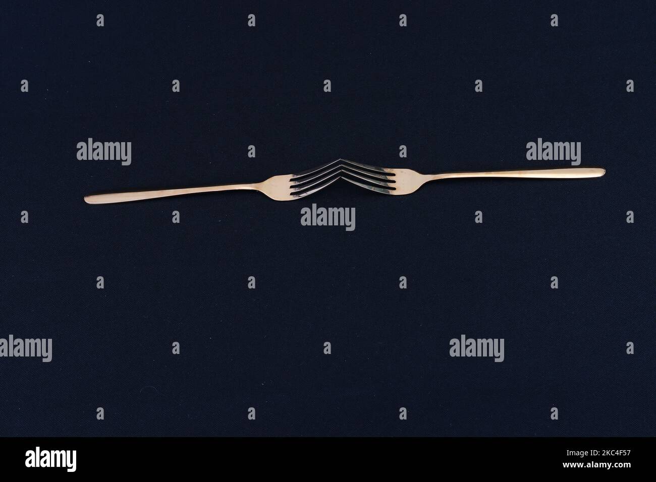 A top view of some forks placed on a dark blue background Stock Photo ...
