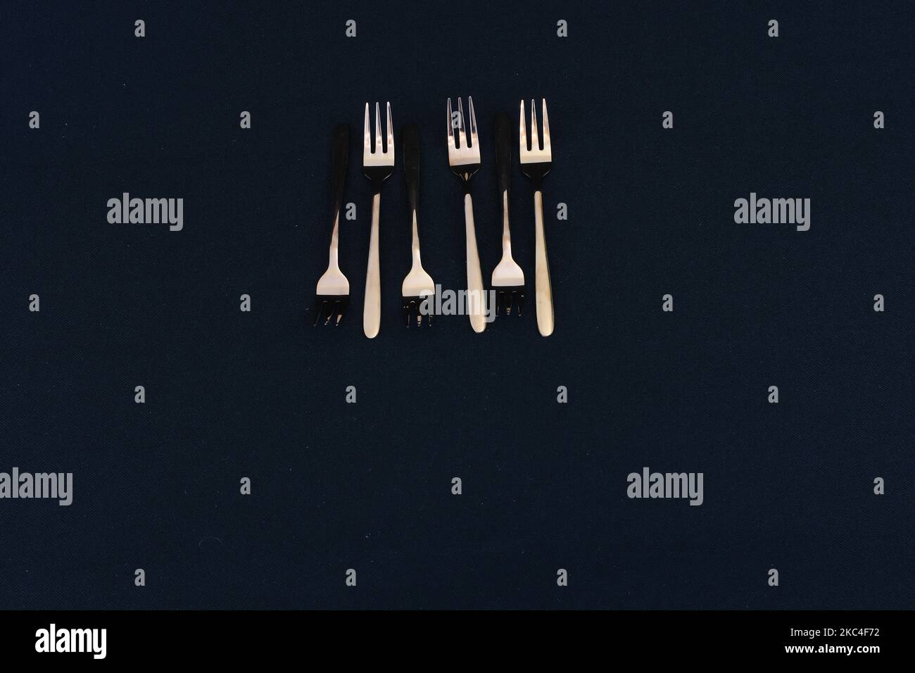 A top view of some forks placed on a dark blue background Stock Photo ...
