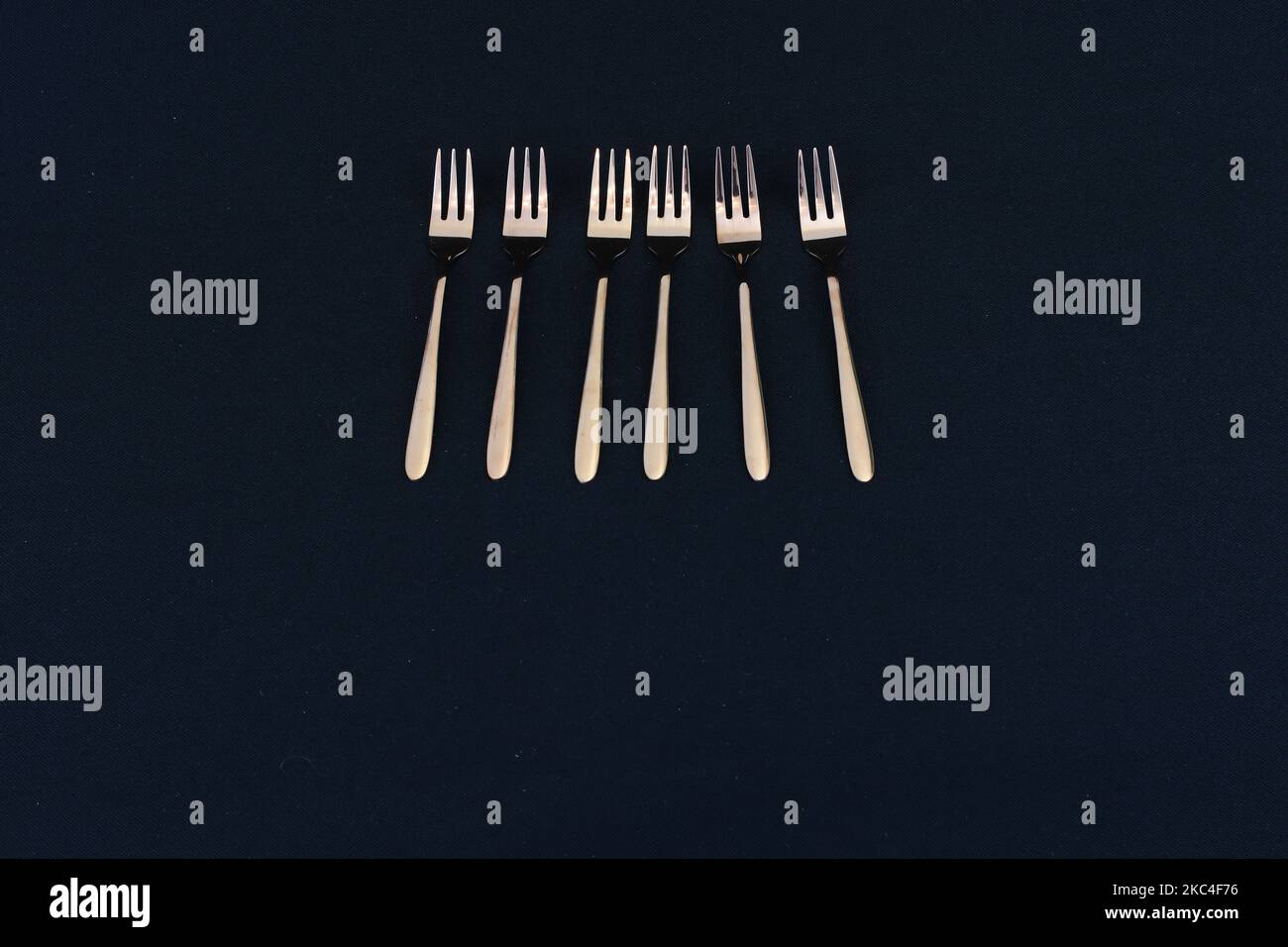 A top view of some forks placed on a dark blue background Stock Photo ...
