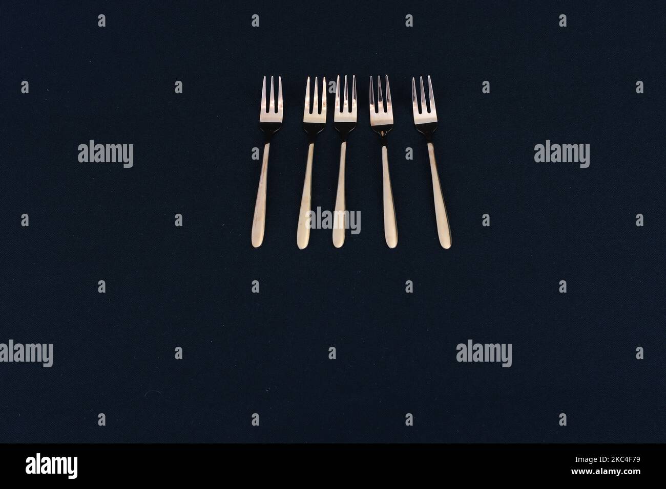 A top view of some forks placed on a dark blue background Stock Photo ...
