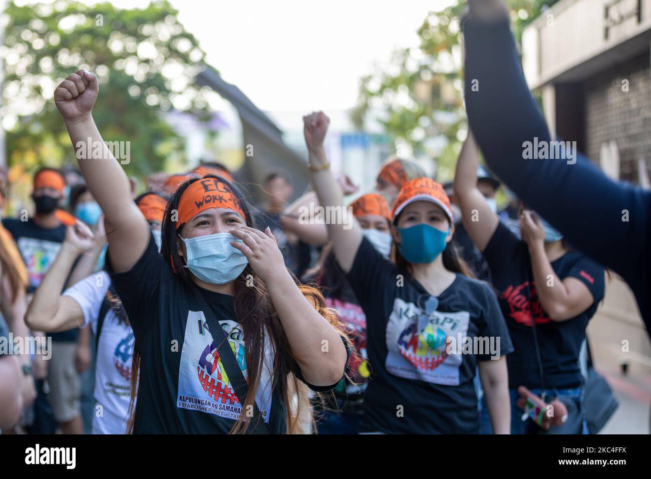 The female immigrant workers holding his fist in the air while asking ...