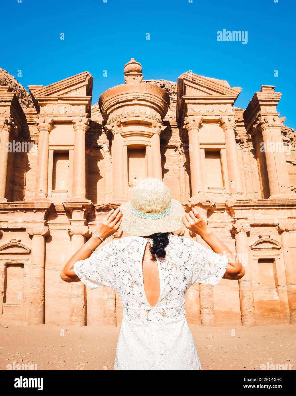 Cinematic Petra background caucasian young woman in white dress and hat ...