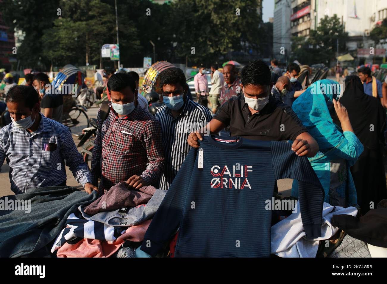 People buy winter clothes from a street vendor amid the COVID-19 ...