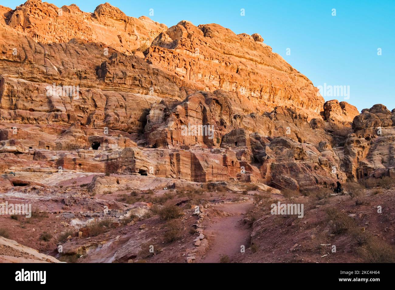 Historical Petra site cave city panorama with pathway on sunset and ...