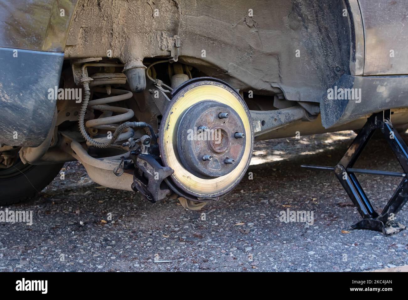 Grey car without wheel and jack close up, repairing Stock Photo - Alamy