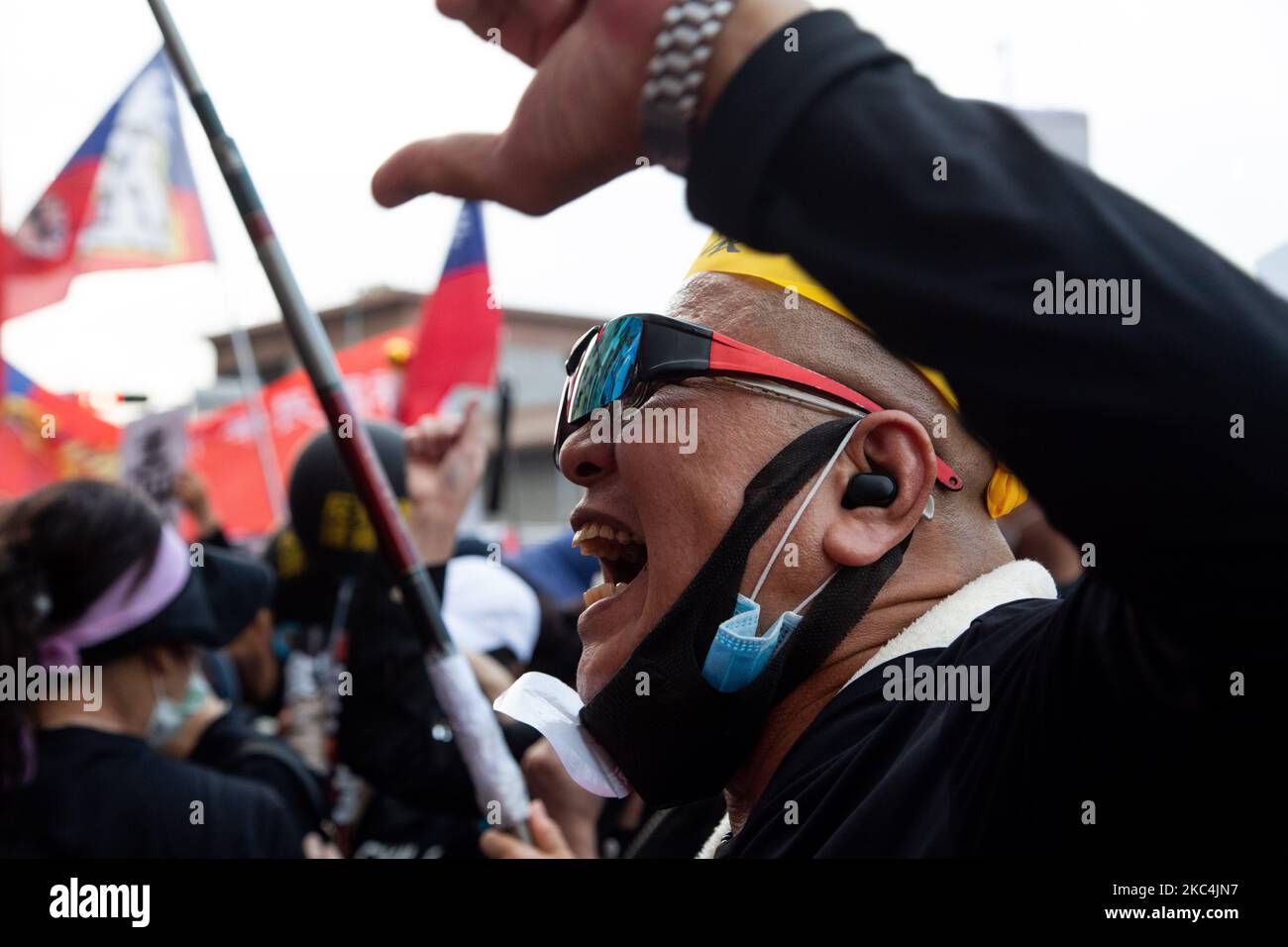 A protest poses a thumbs-down gesture during a protest in Taipei ...
