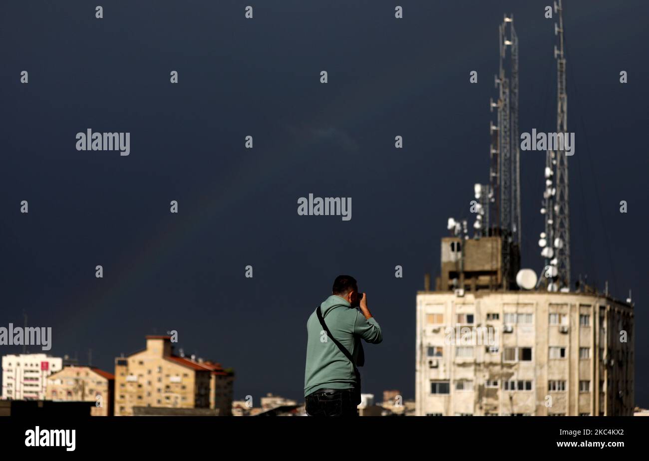 A photojournalist takes a picture of a rainbow over Gaza City after a ...
