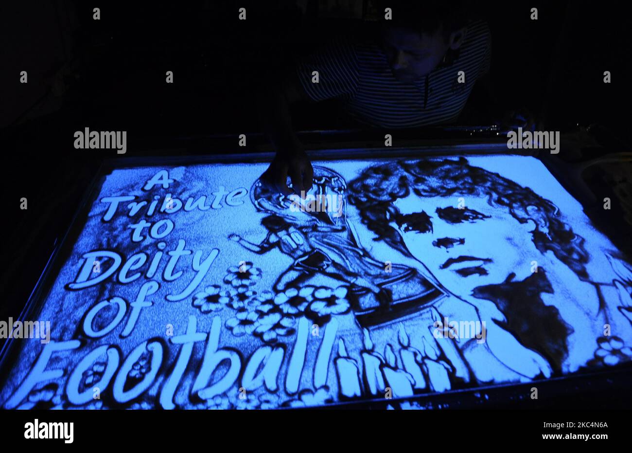 A sand animation of football legend Diego Maradona is seen as it is ...