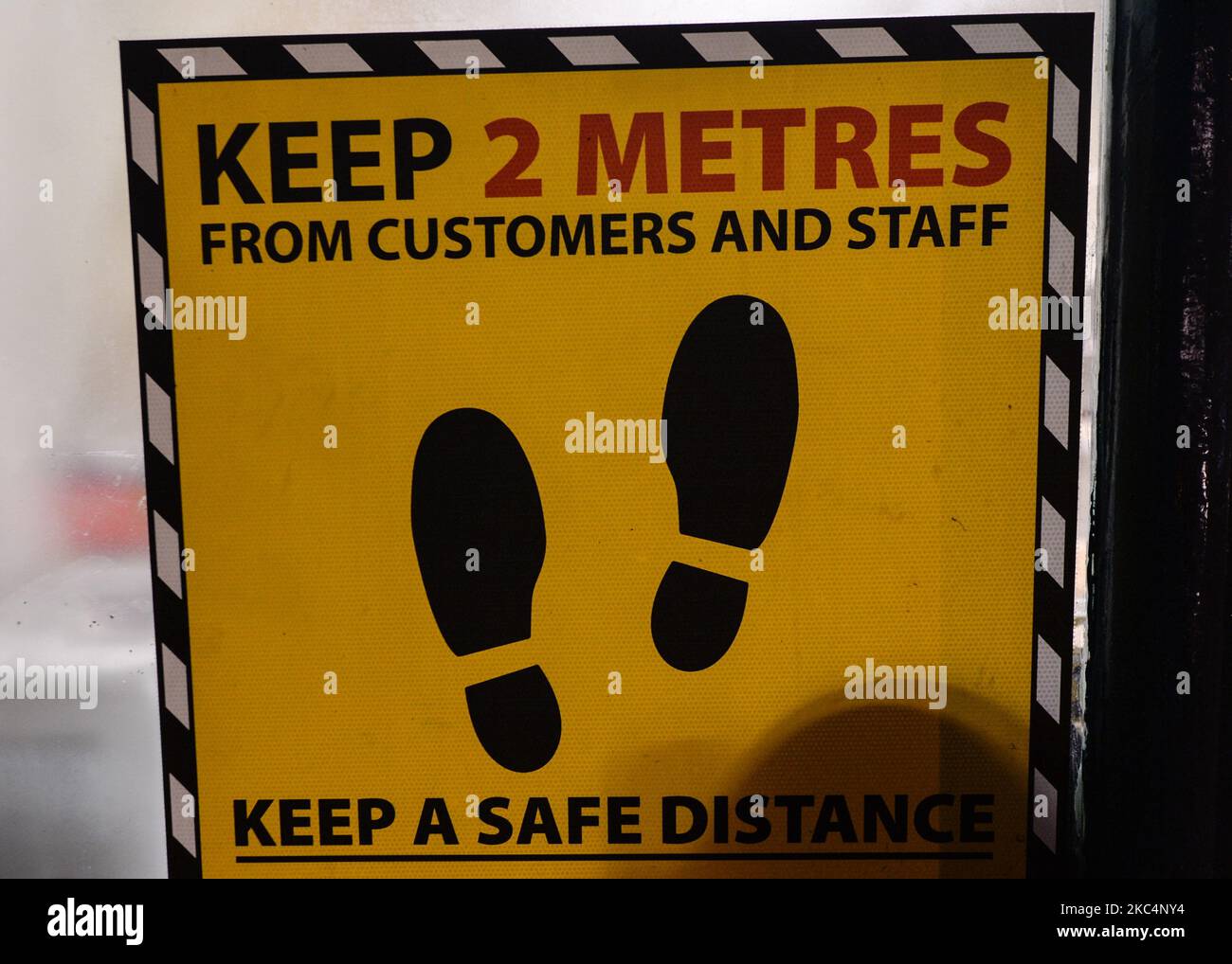 A sign 'Keep 2 metres from customers and staff' seen at the entrance to ...