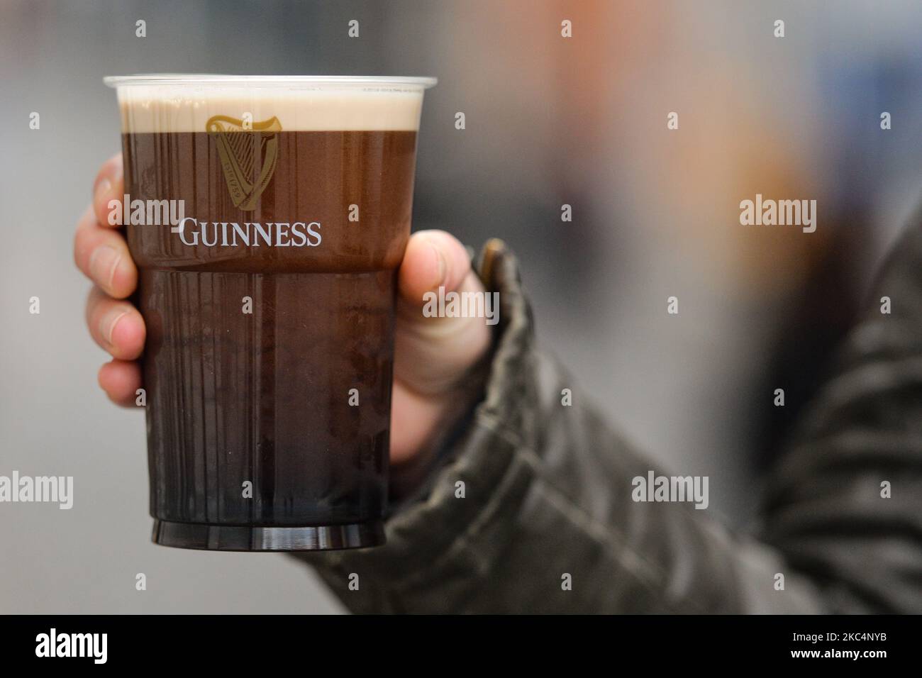 A pint of Guinness just pulled in a plastic cup seen outside a pub in ...