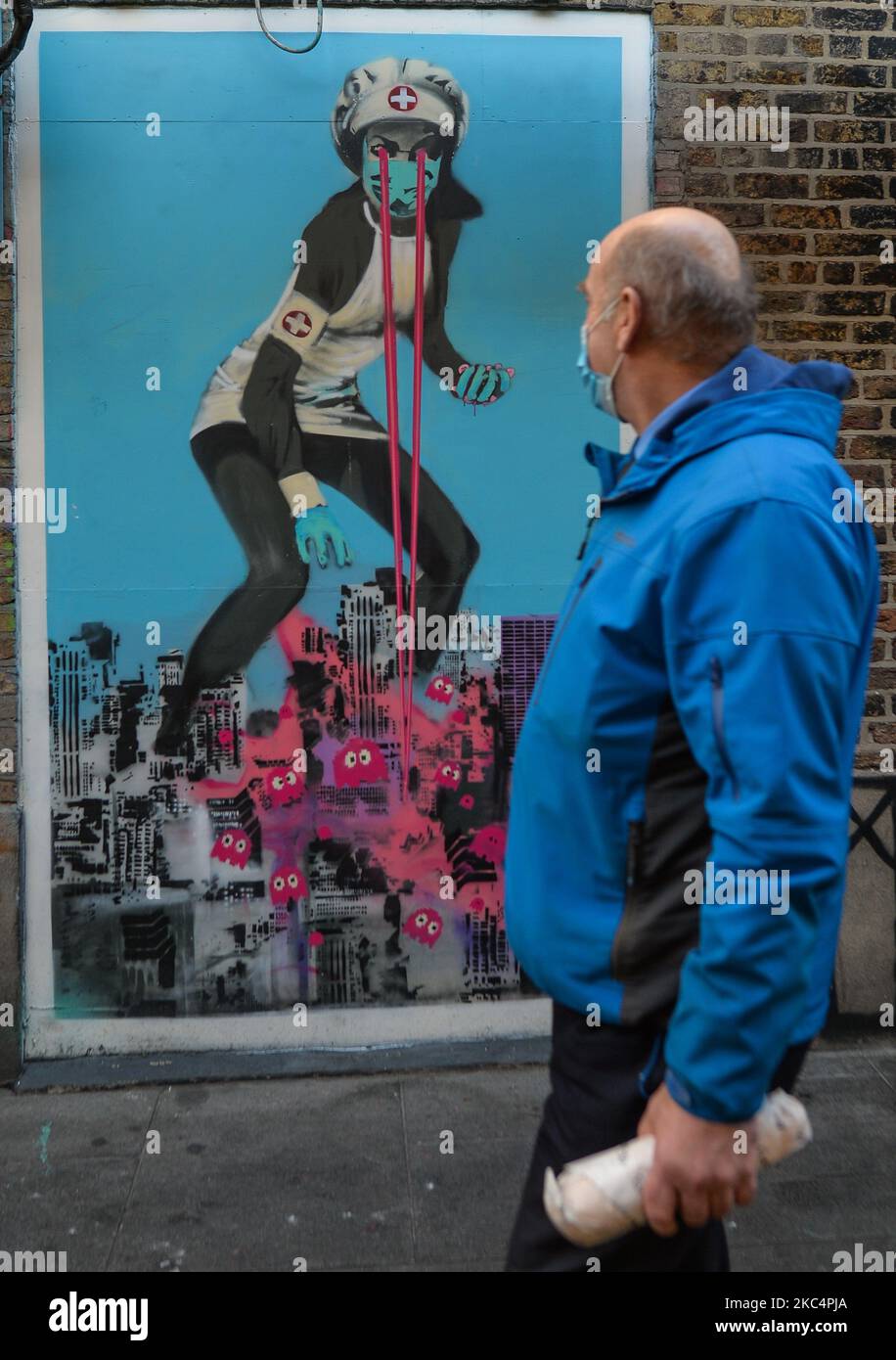 A man walks by the mural '50 FT HEROES' by the Irish artist Shane ...