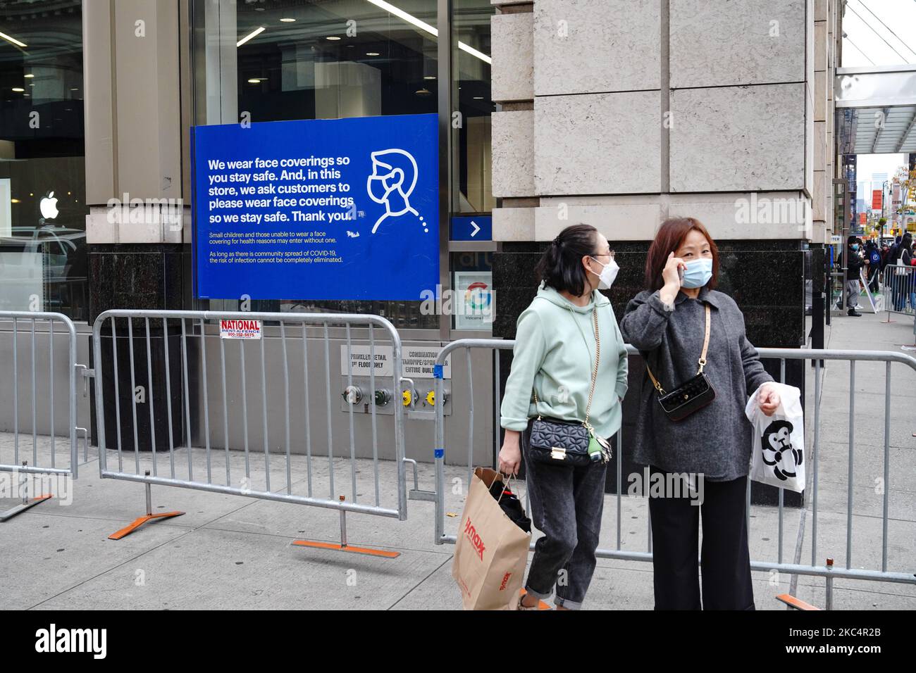 A view of people wearing masks in front of empty shopping lines at a ...