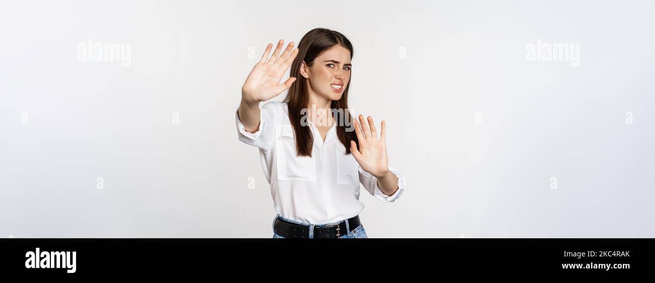 Displeased woman showing stop, rejection gesture, waving hands to ...